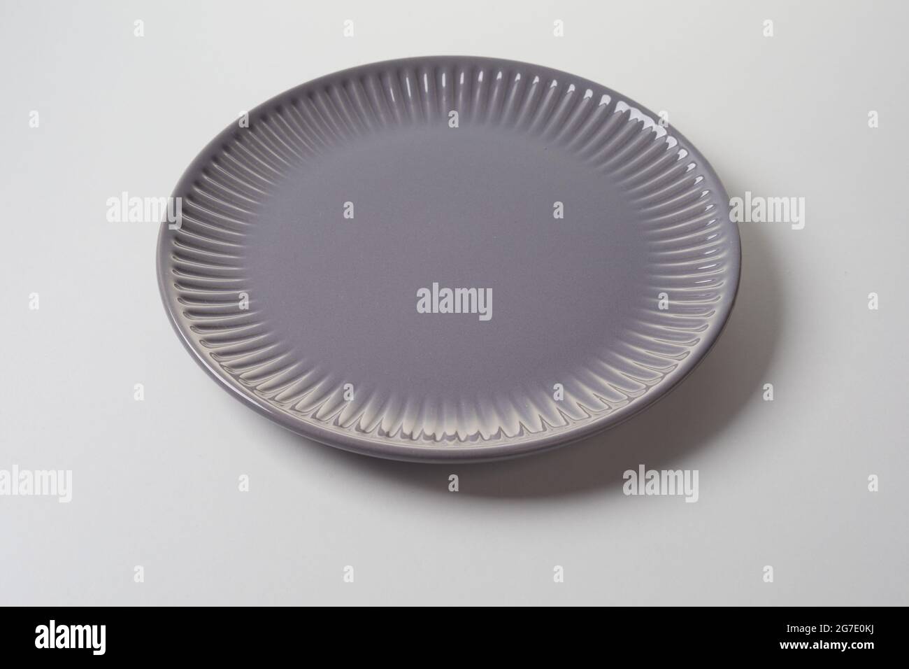 Stylish clean empty grey ceramic plate with fluted patterned rim for ...