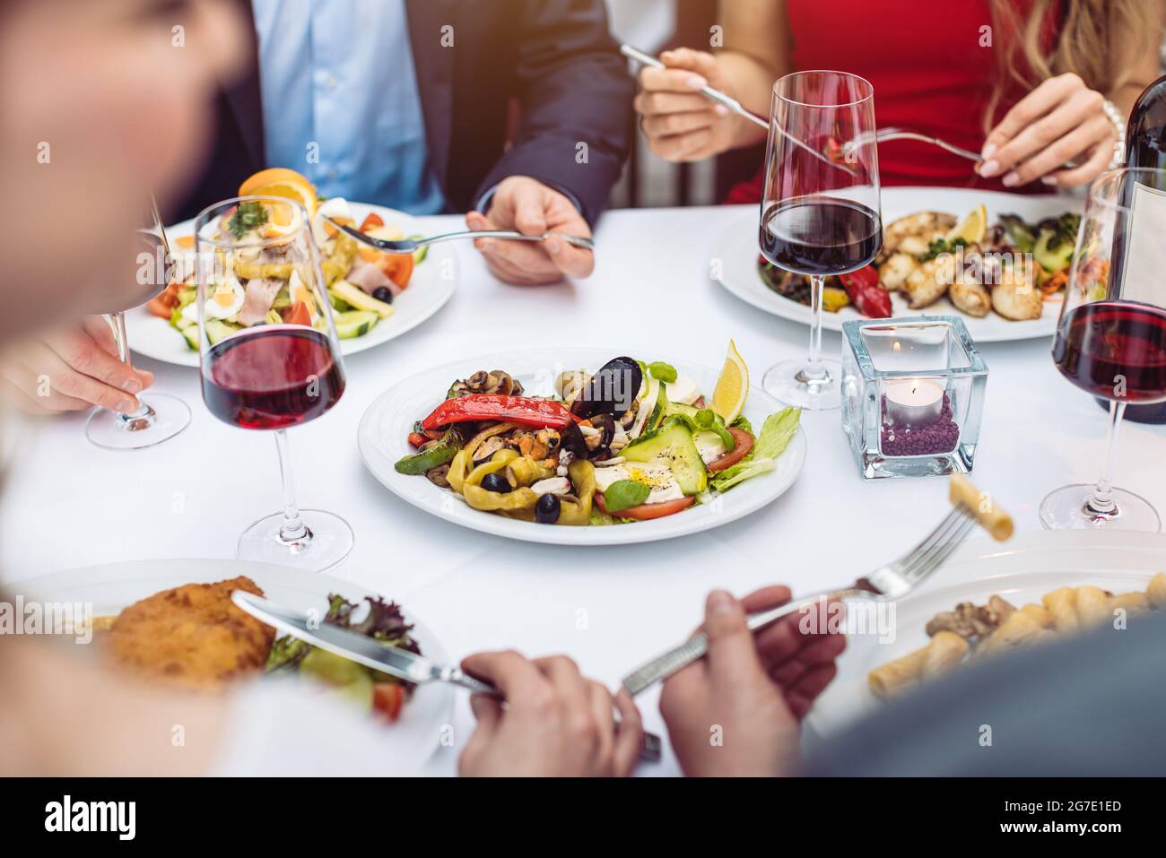 Four friends eating Italian food in fancy restaurant, close-up on the ...