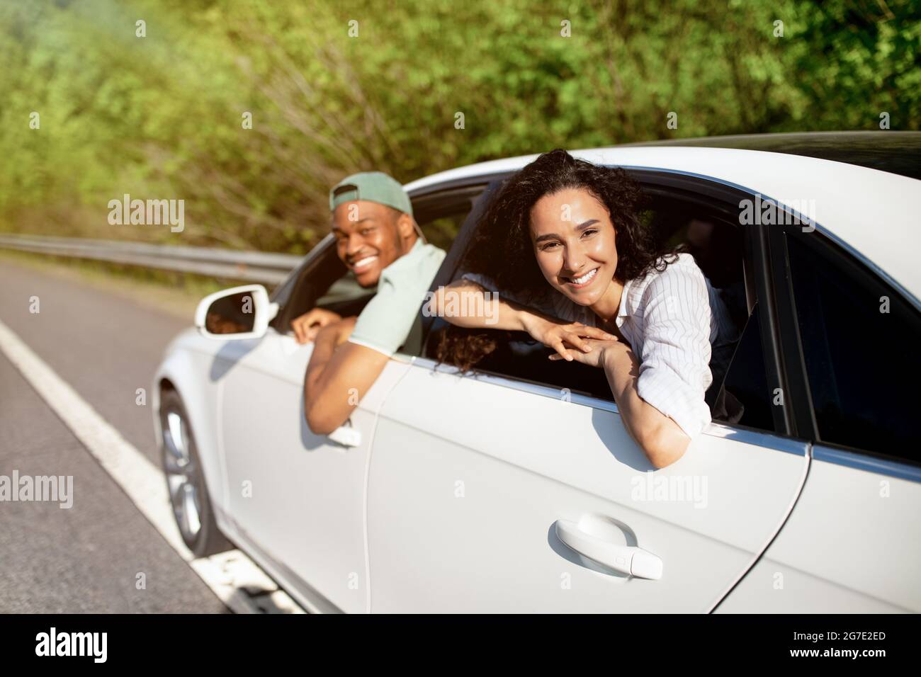 Multiracial people riding auto, looking through windows, going on ...