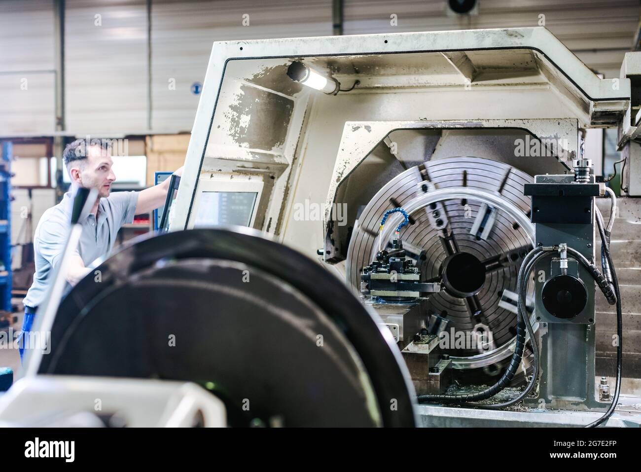 Worker man operating a CNC lathe in factory Stock Photo - Alamy