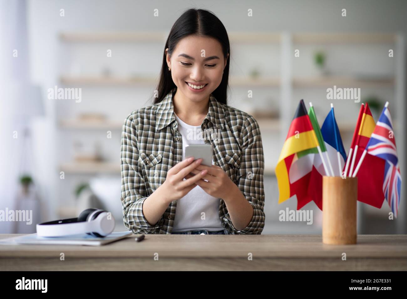 Cheerful asian young woman using cellphone, having English class Stock ...