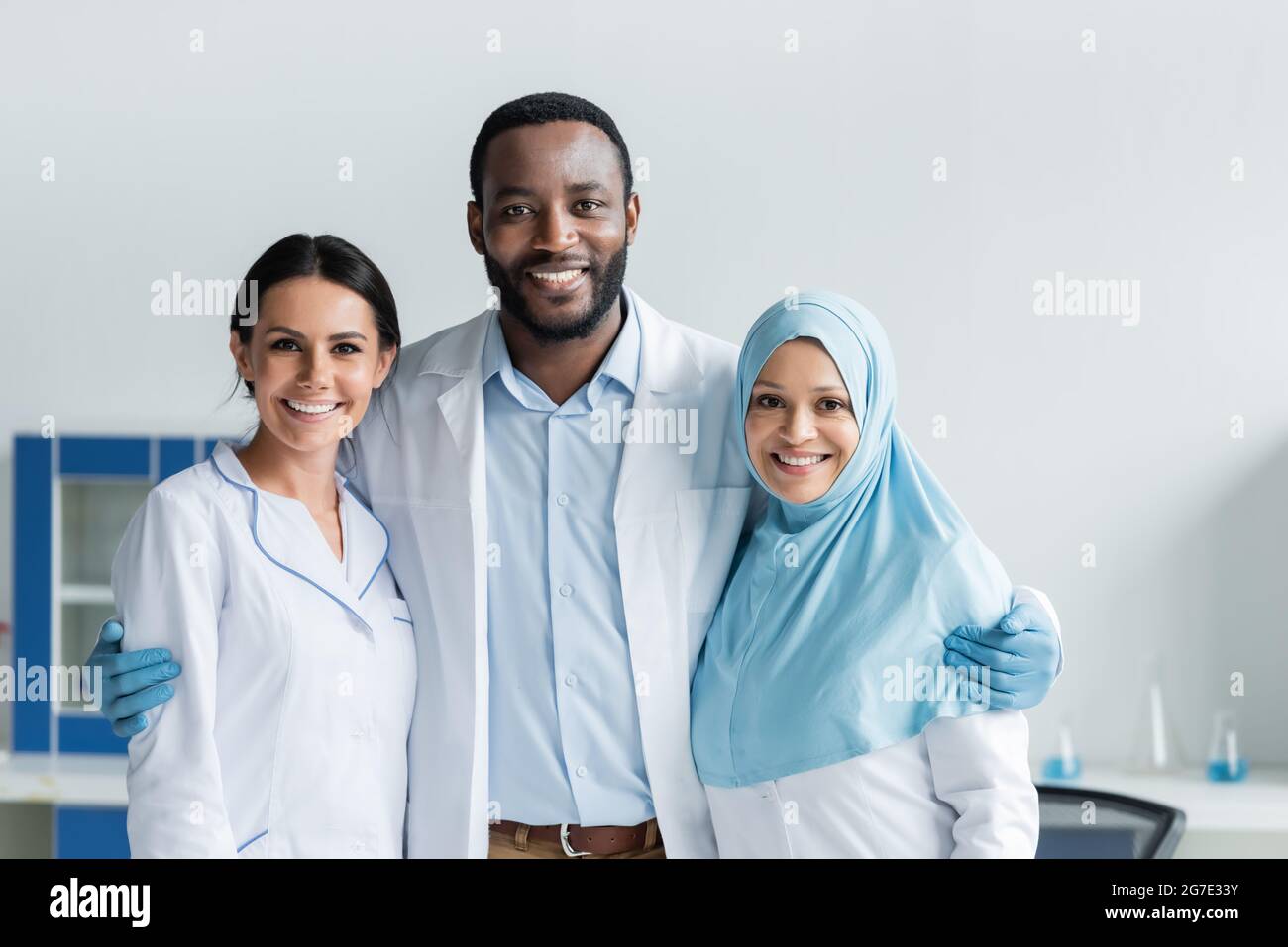 Cheerful multicultural scientists hugging in laboratory Stock Photo - Alamy