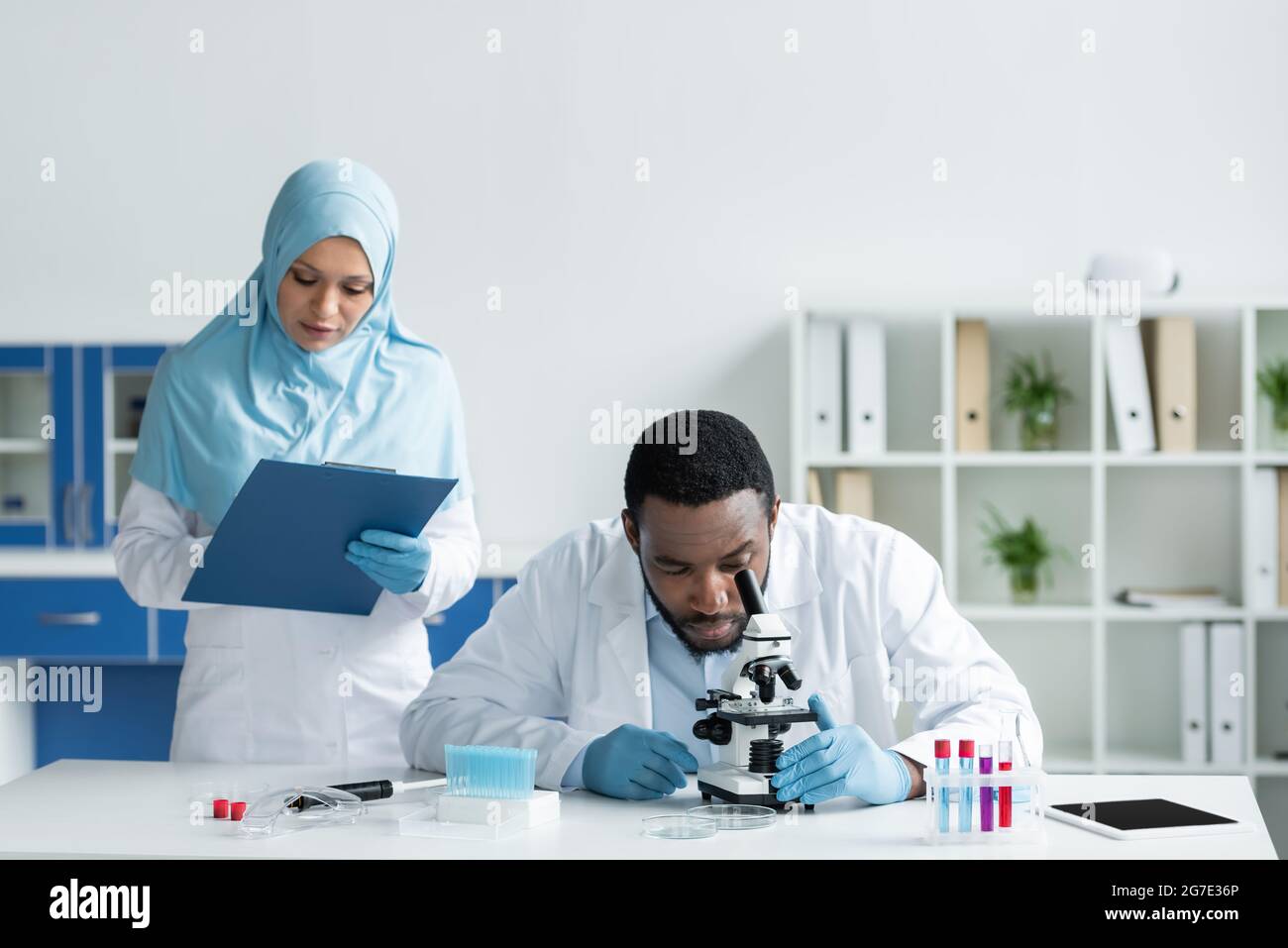 Black man looking through microscope hi-res stock photography and ...