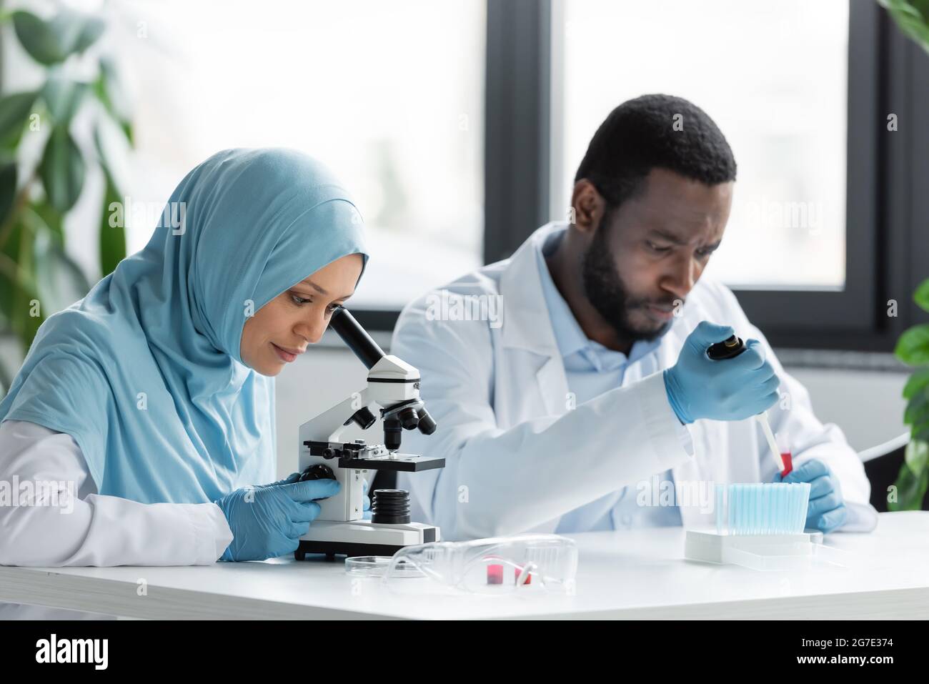 Black woman looking through microscope hi-res stock photography and ...