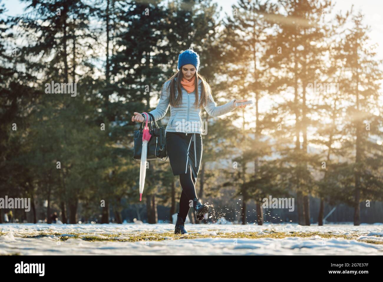 Woman walking thru slushy snow on a meadow Stock Photo - Alamy