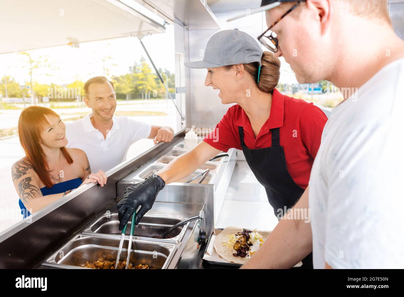 People standing in line in front of food truck waiting for their meal ...