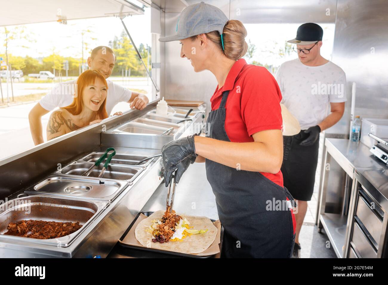 People standing in line in front of food truck waiting for their meal ...