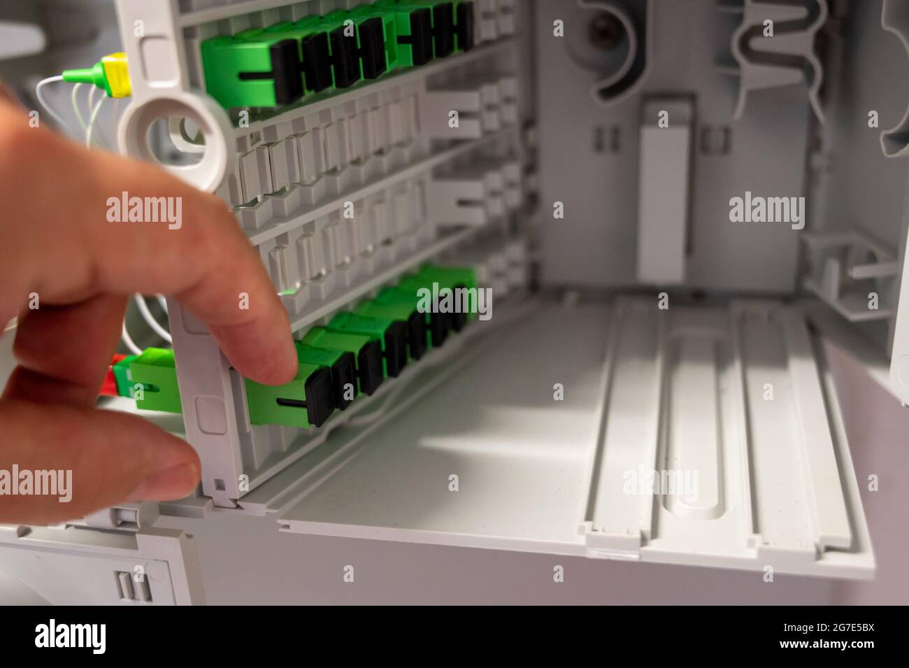 A technician at work: close up shot of the hand checking the cabling of ...