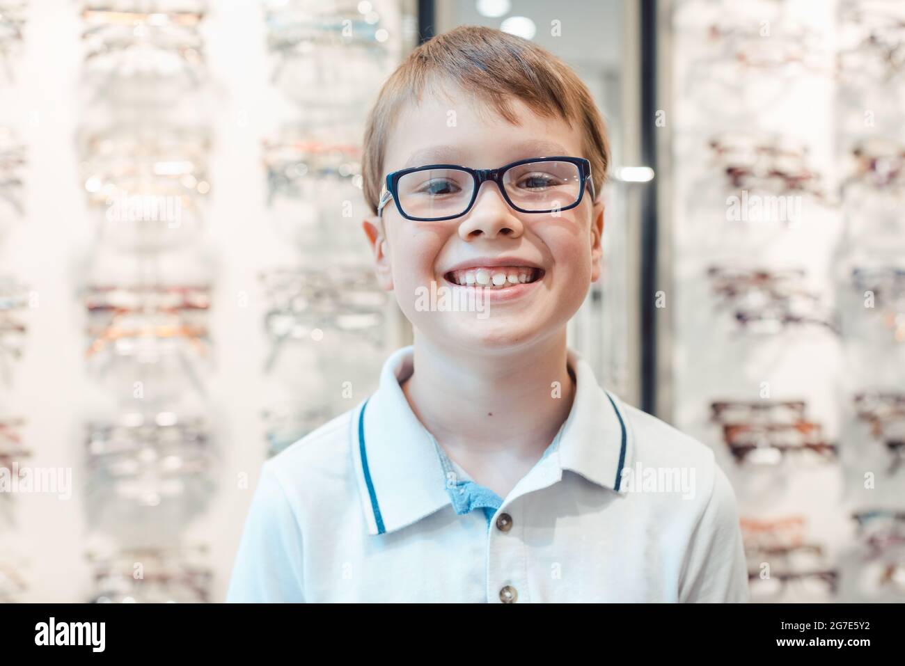 Young boy liking the new glasses he has got from the optician smiling ...