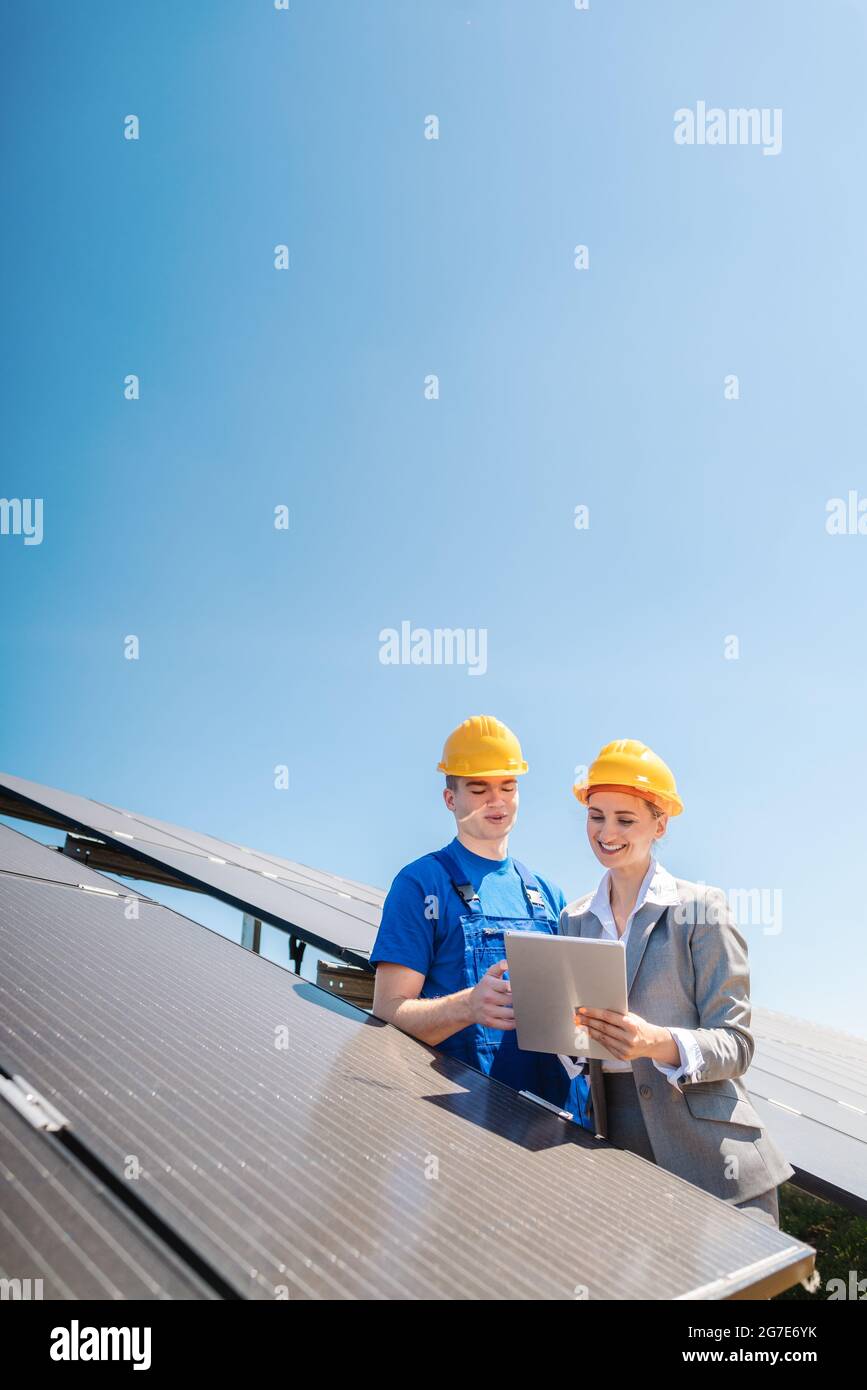 Manager and worker in photovoltaic power plant discussing maintenance ...