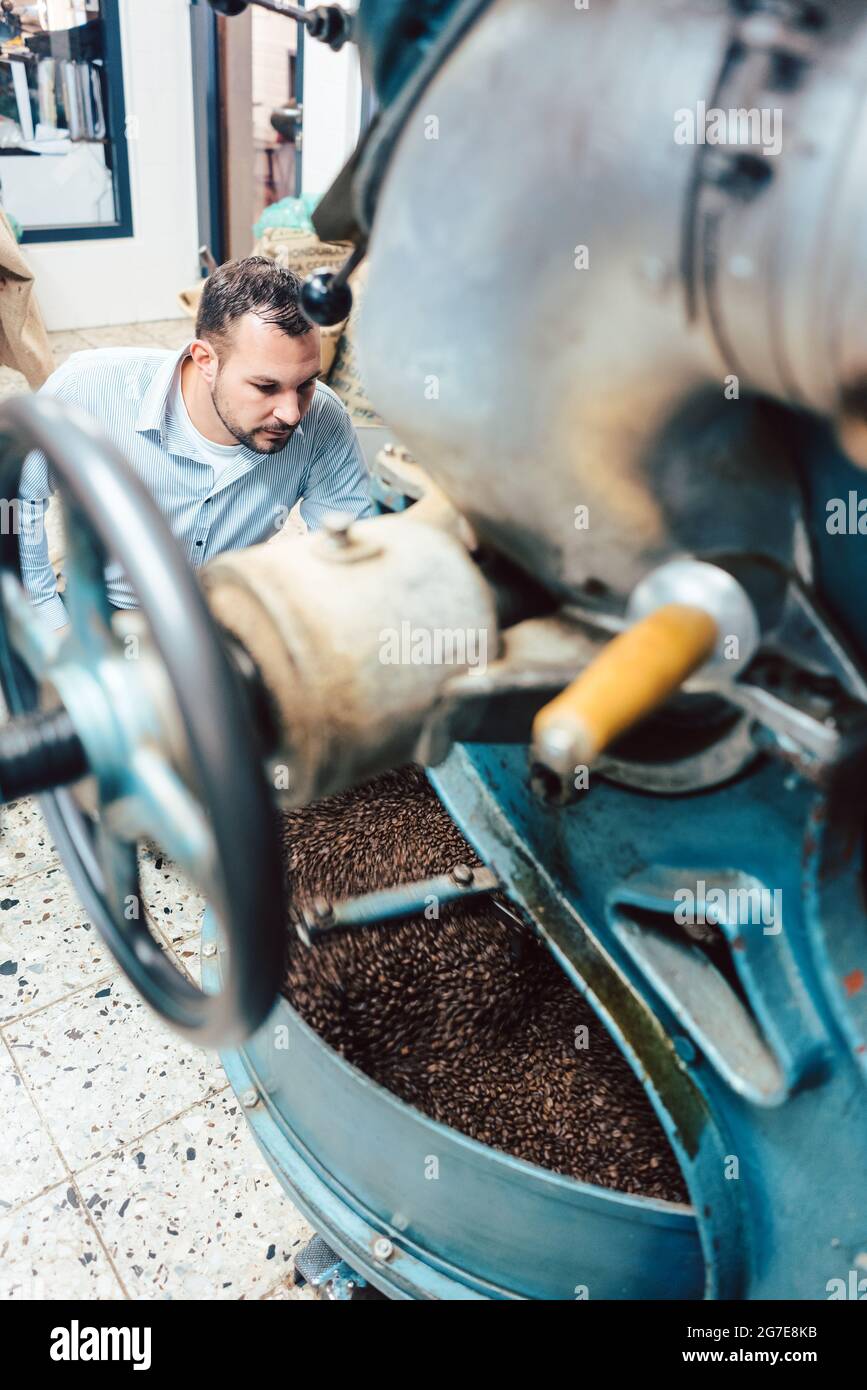 Man operating coffee roaster in his factory Stock Photo - Alamy