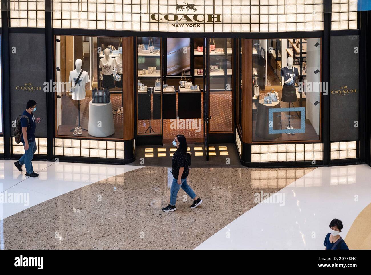 Shoppers walk past the American multinational fashion and luxury ...