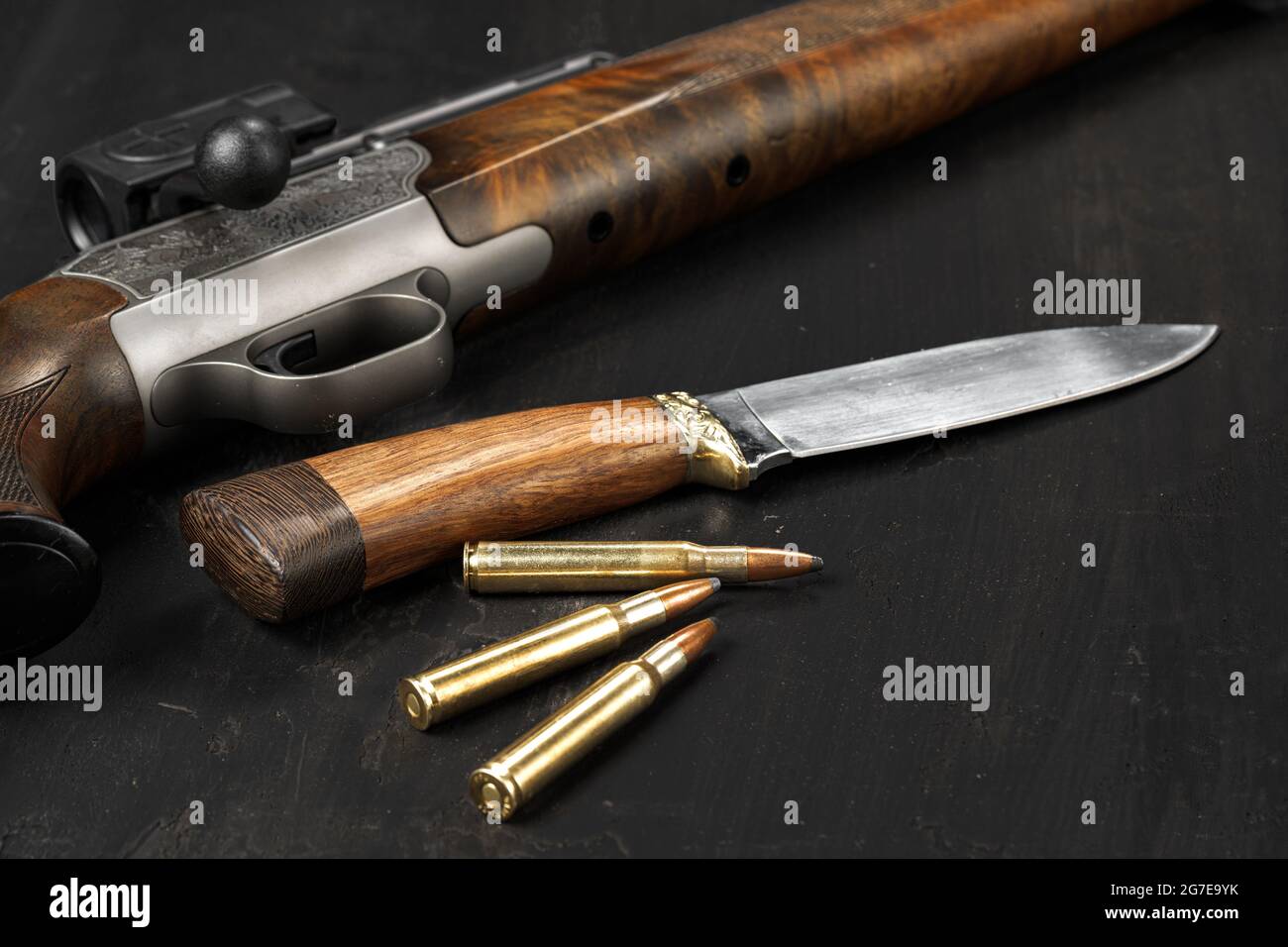 Hunting rifle and cartridges on dark wooden background Stock Photo - Alamy