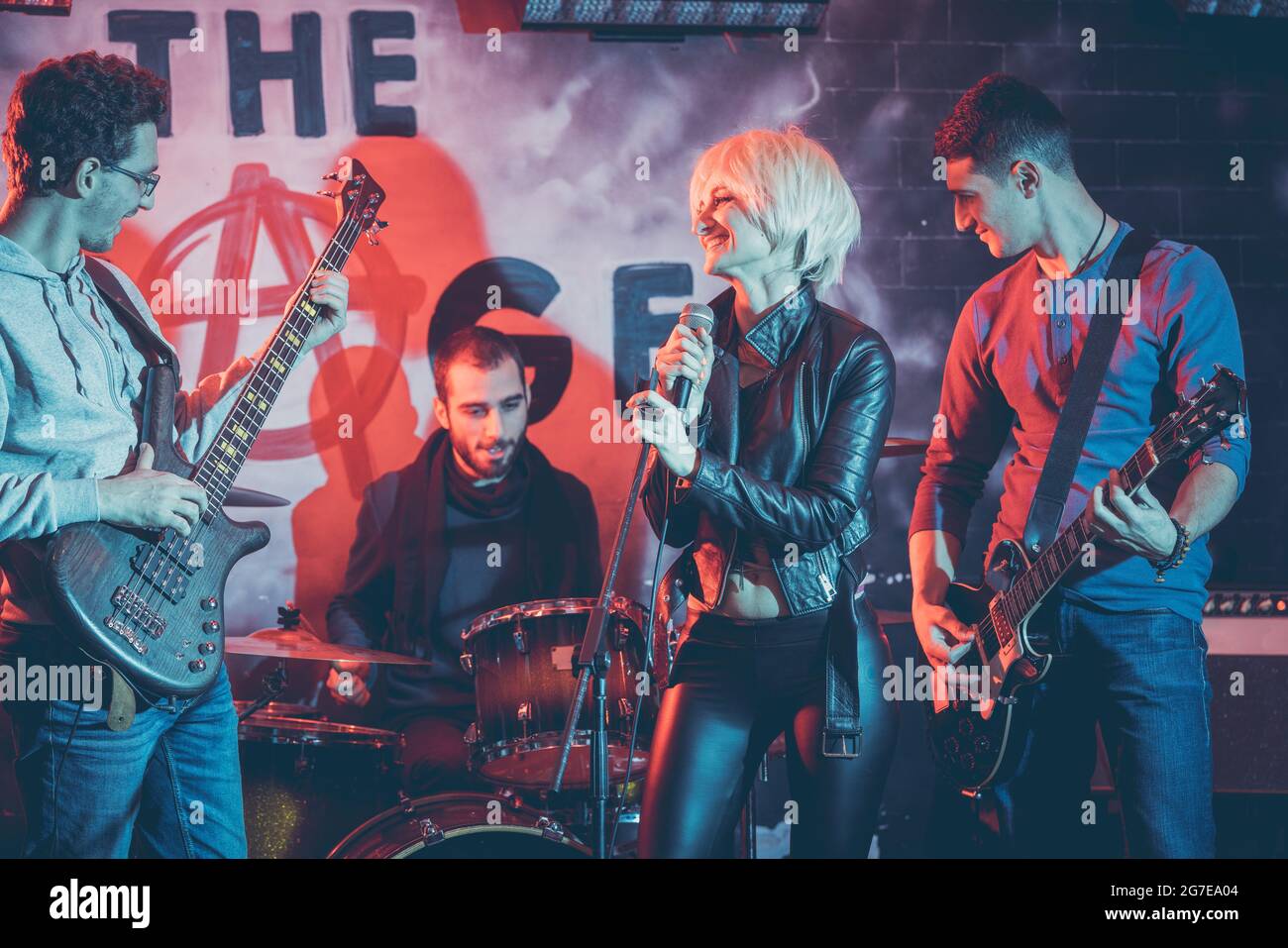 Band playing on stage making music together Stock Photo - Alamy