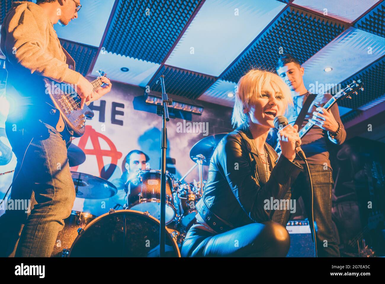 Band playing on stage making music together Stock Photo - Alamy