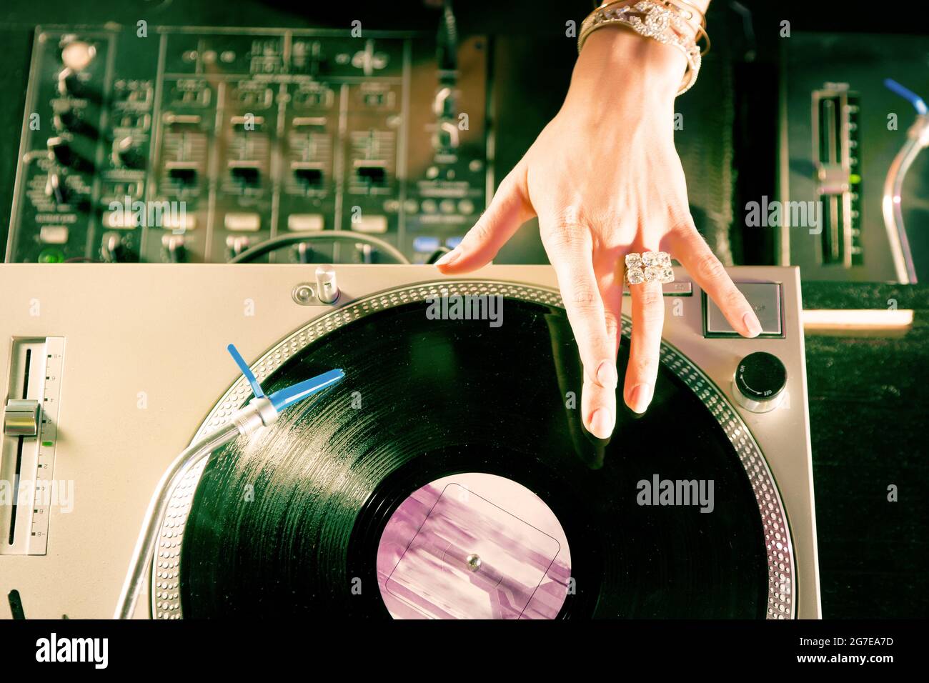 Female DJ at the turntable in a club, with mixer and old school record ...