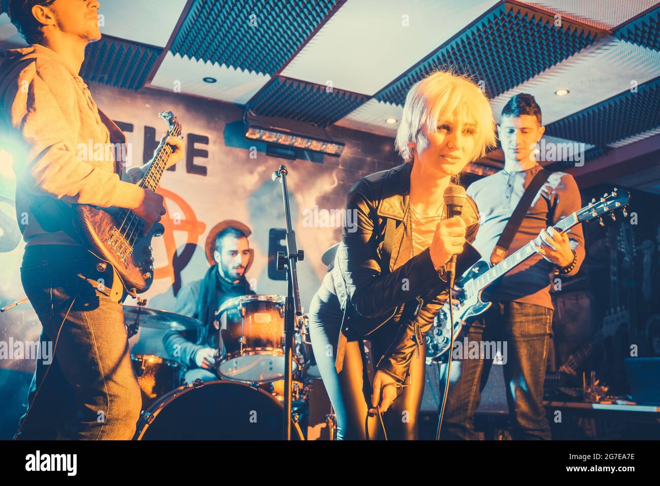 Band playing on stage making music together Stock Photo - Alamy