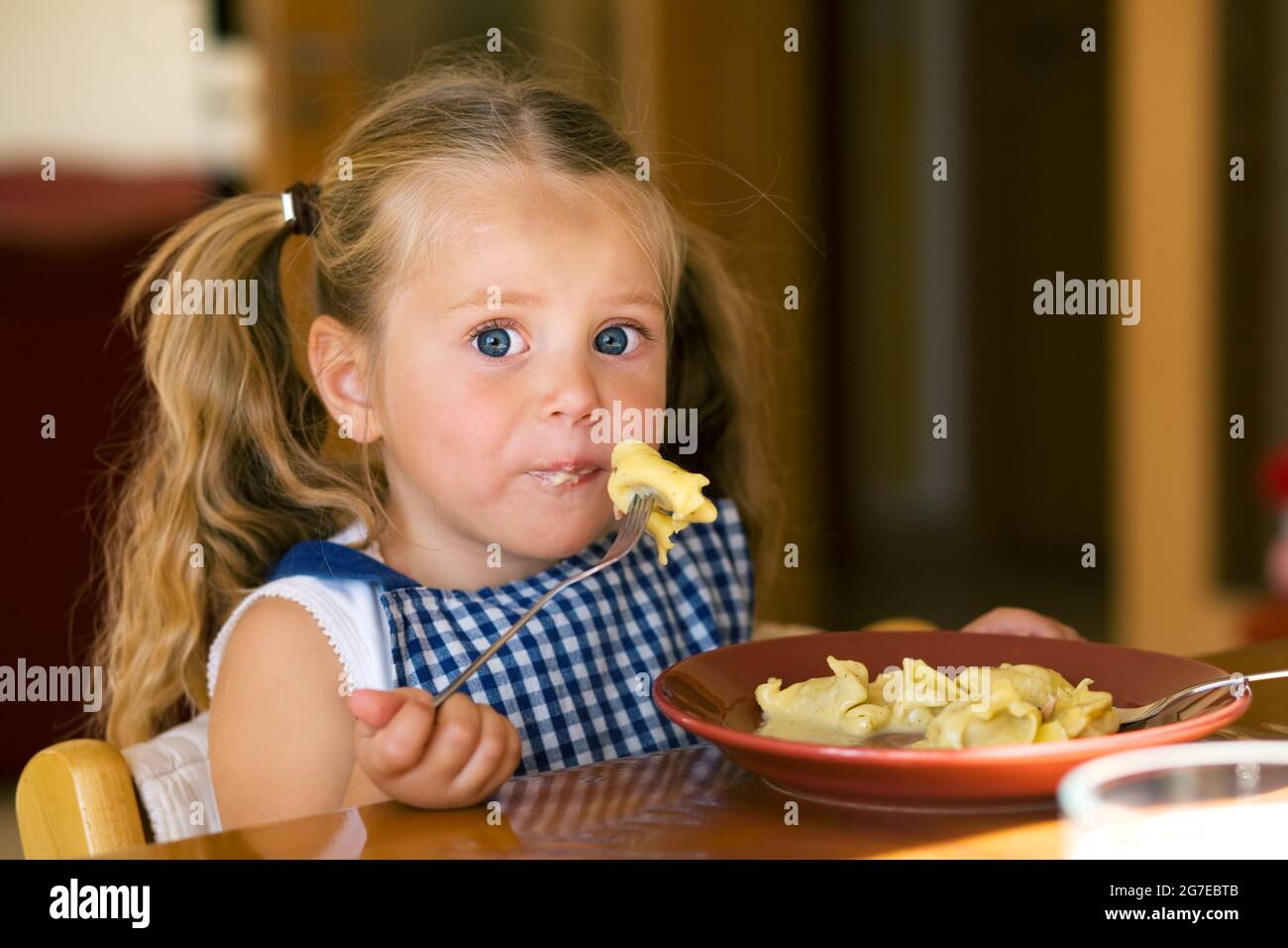 Young girl eating pasta Stock Photo - Alamy
