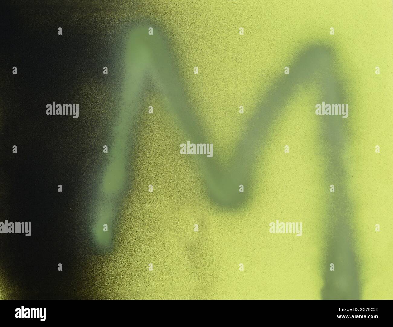 spray painted letter M on black and yellow spray wallpaper background ...