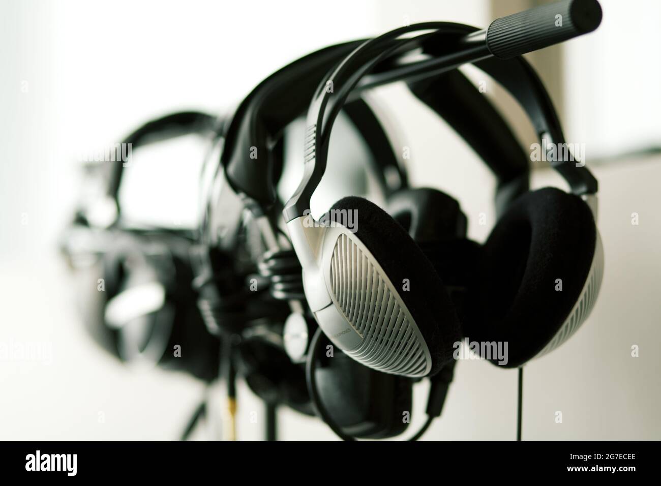 A set of studio headphones hanging on a rack Stock Photo - Alamy