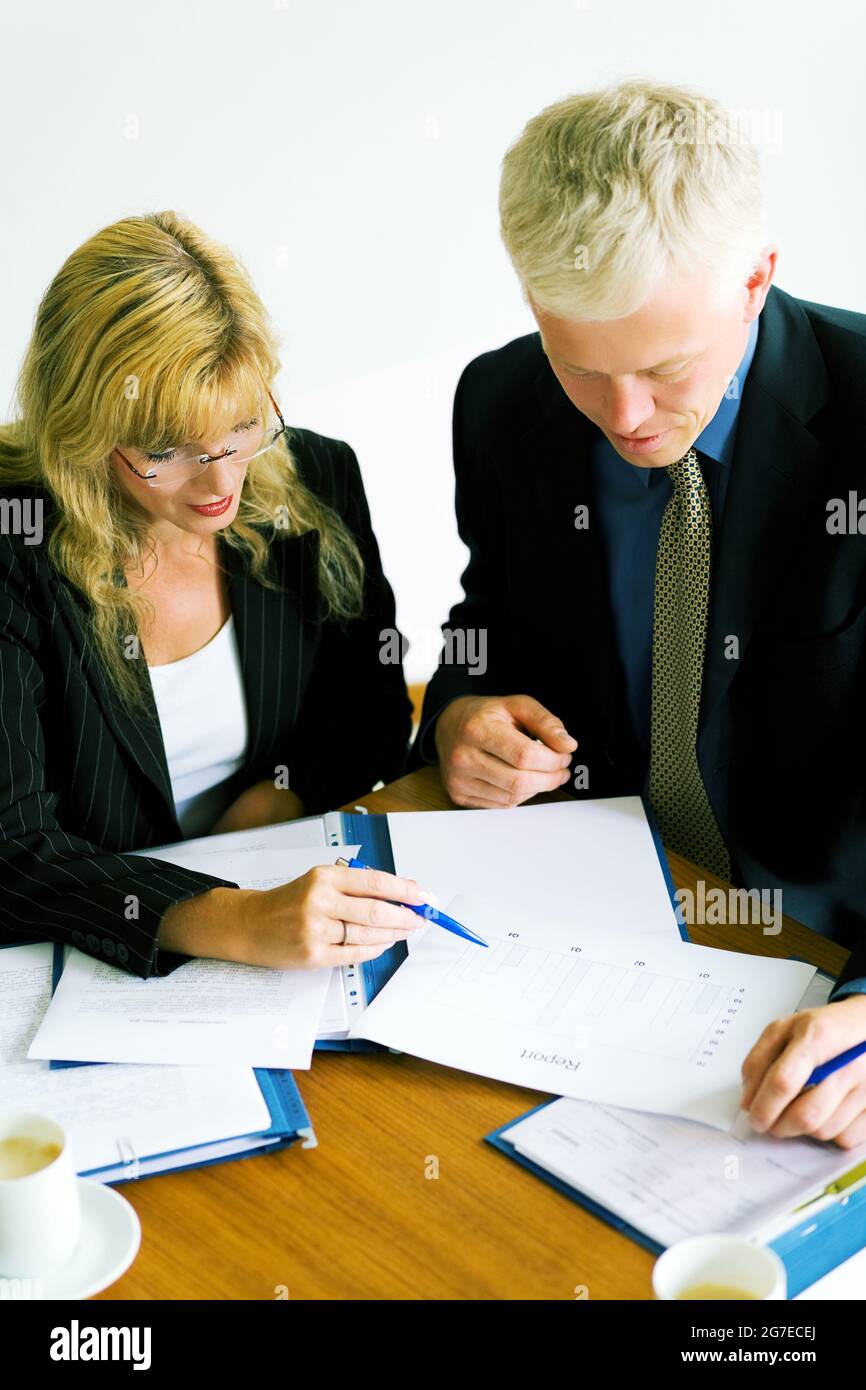 Two business people discussing a report Stock Photo - Alamy