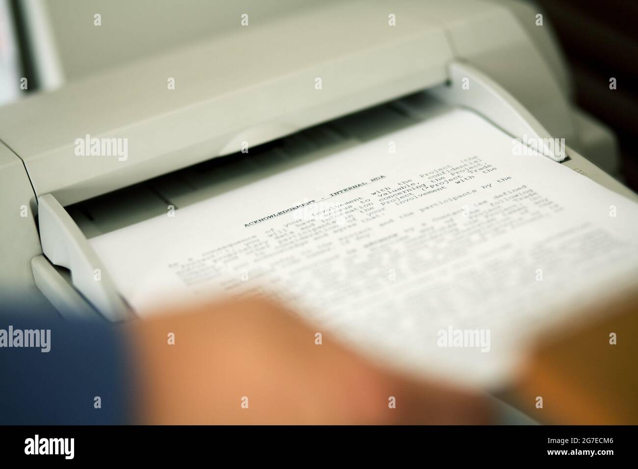 A man (only hand to be seen) faxing a non disclosure agreement or ...