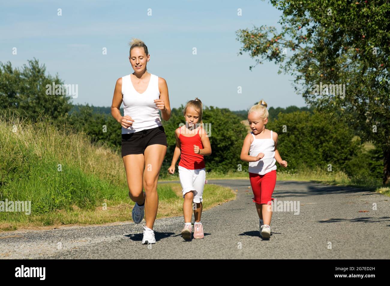A young mom running with two daughters Stock Photo - Alamy