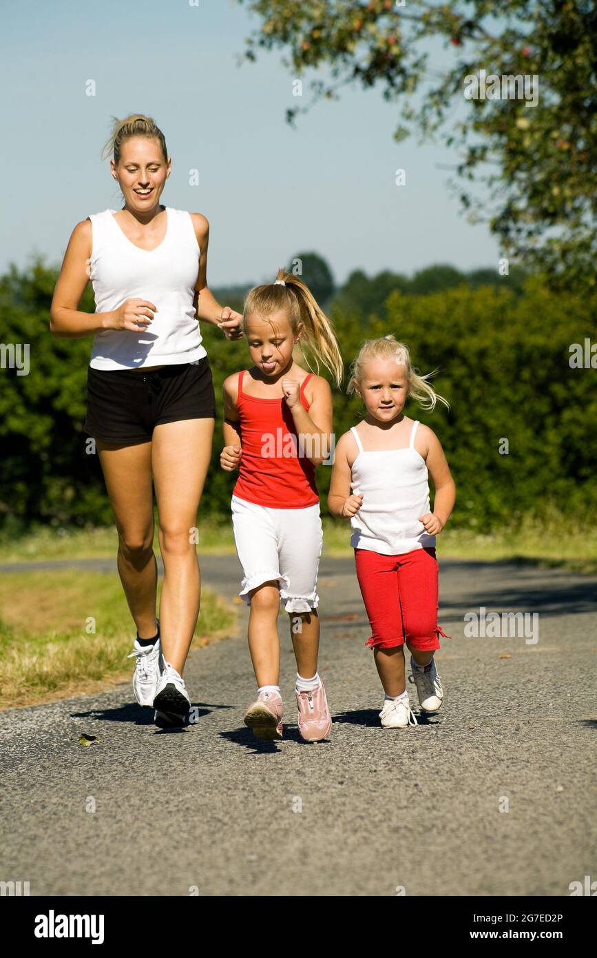 A young mom running with two daughters Stock Photo - Alamy