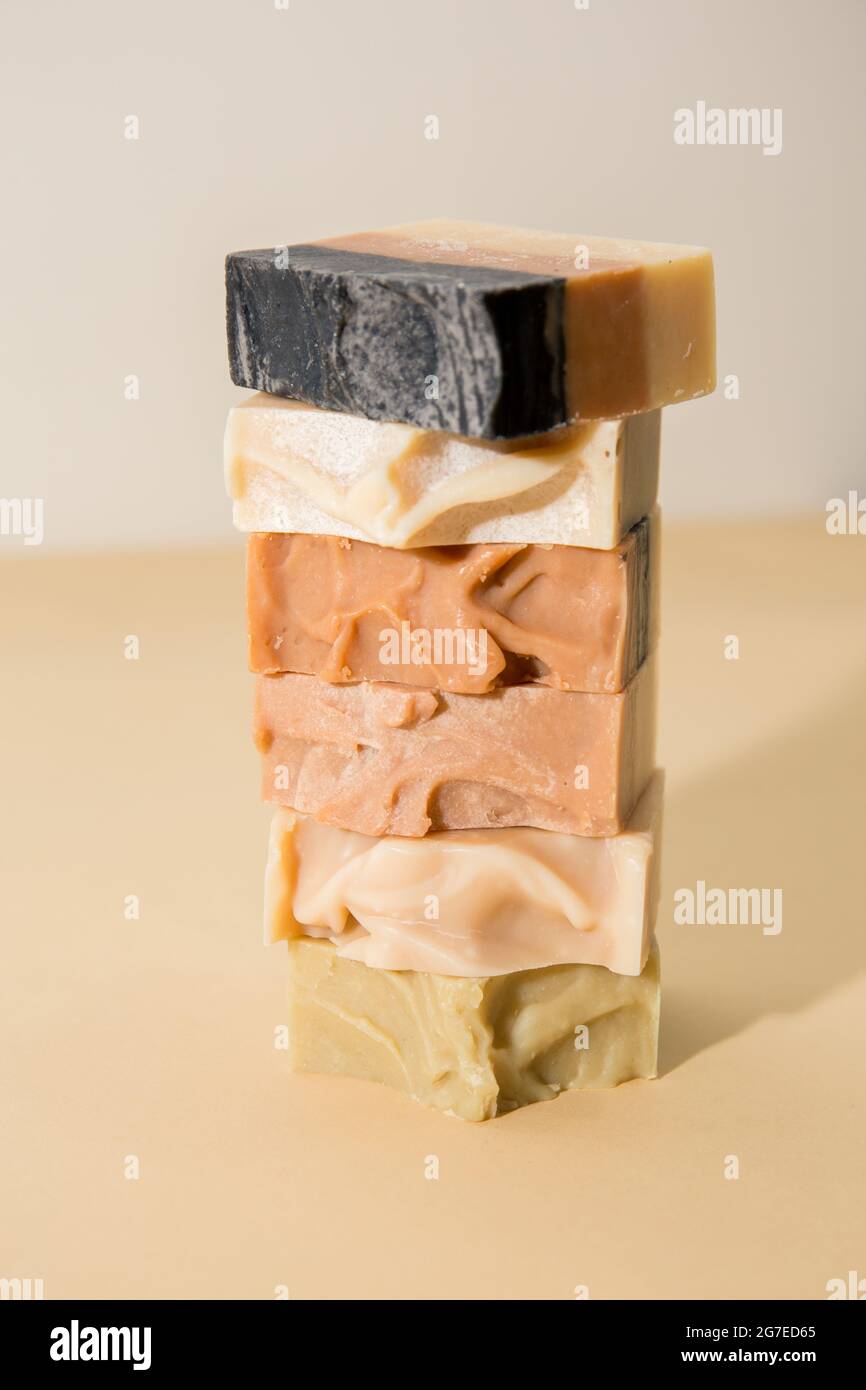 Vertical shot of stacked handmade bars of hand soap on a beige surface ...