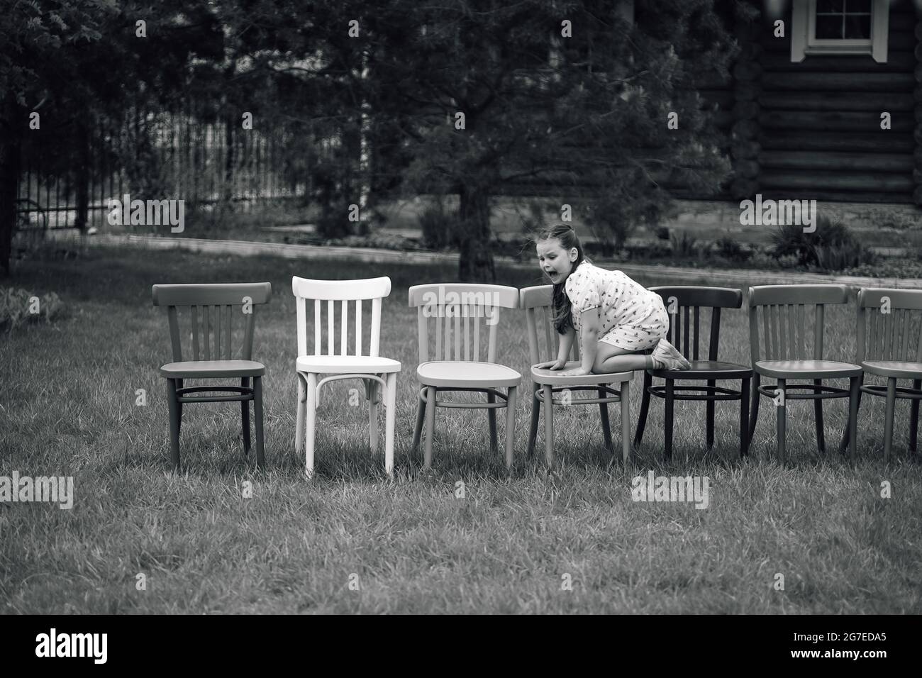a black-and-white frame from a horror movie, a frightened girl climbed ...