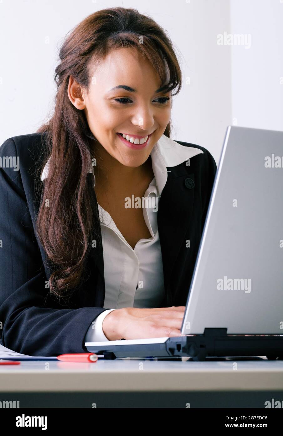 Young woman working on a laptop computer, laughing Stock Photo - Alamy