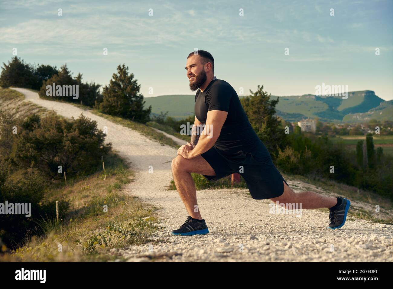 Male athlete warming up before start running in mountains Stock Photo ...