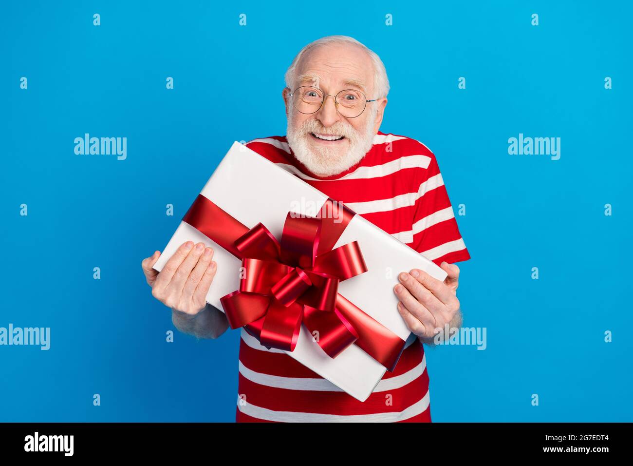 Photo of optimistic old grey hairdo man hold present wear red t-shirt ...