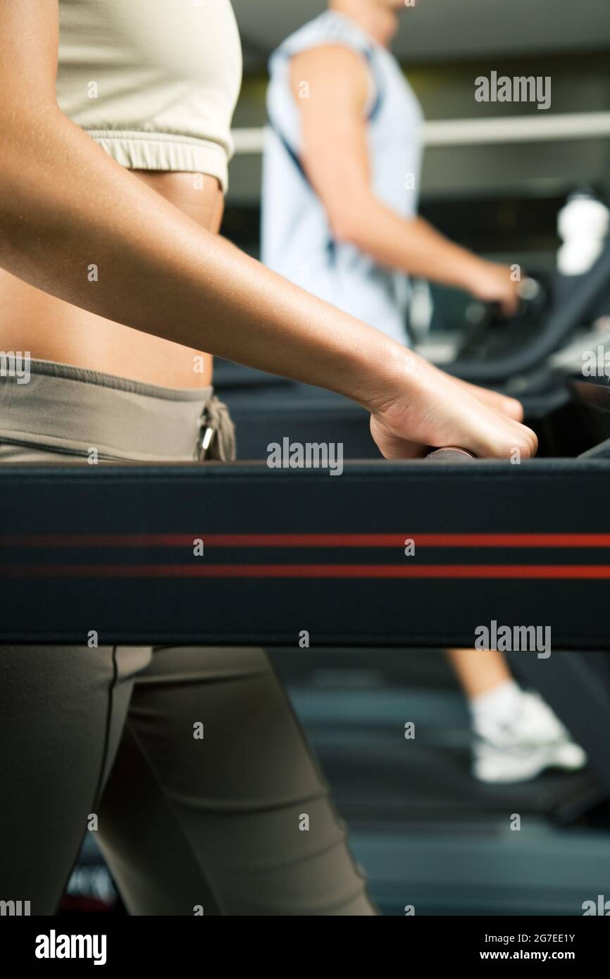 Two people (male / female) working out on a treadmill in a gym Stock ...
