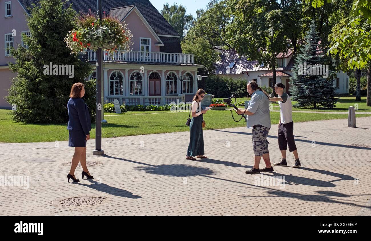 Ogre News Media team at work, camera operator with assistant filming an ...