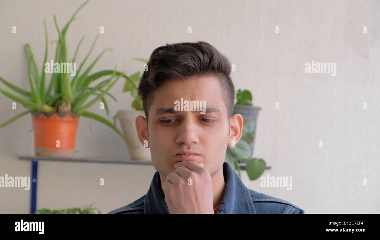 Handsome young Indian male looking at something with a serious face and ...