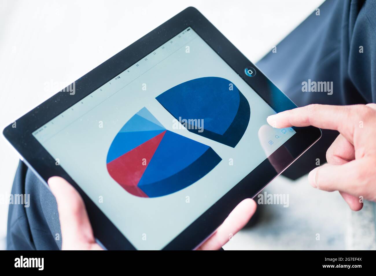 Businessman working on a statistical pie chart on a tablet computer ...