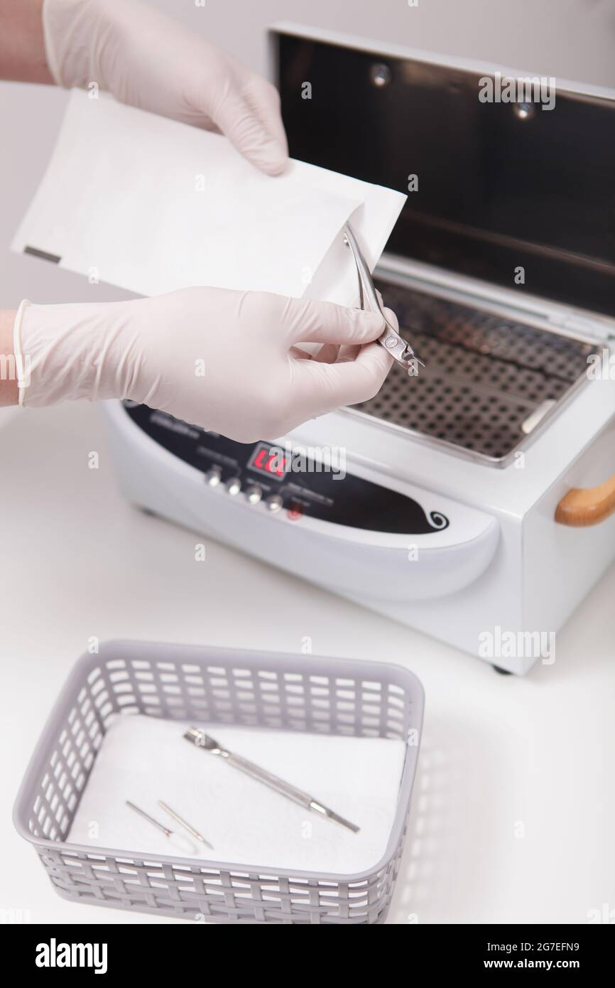 Vertical cropped shot of manicurist putting instruments into ...