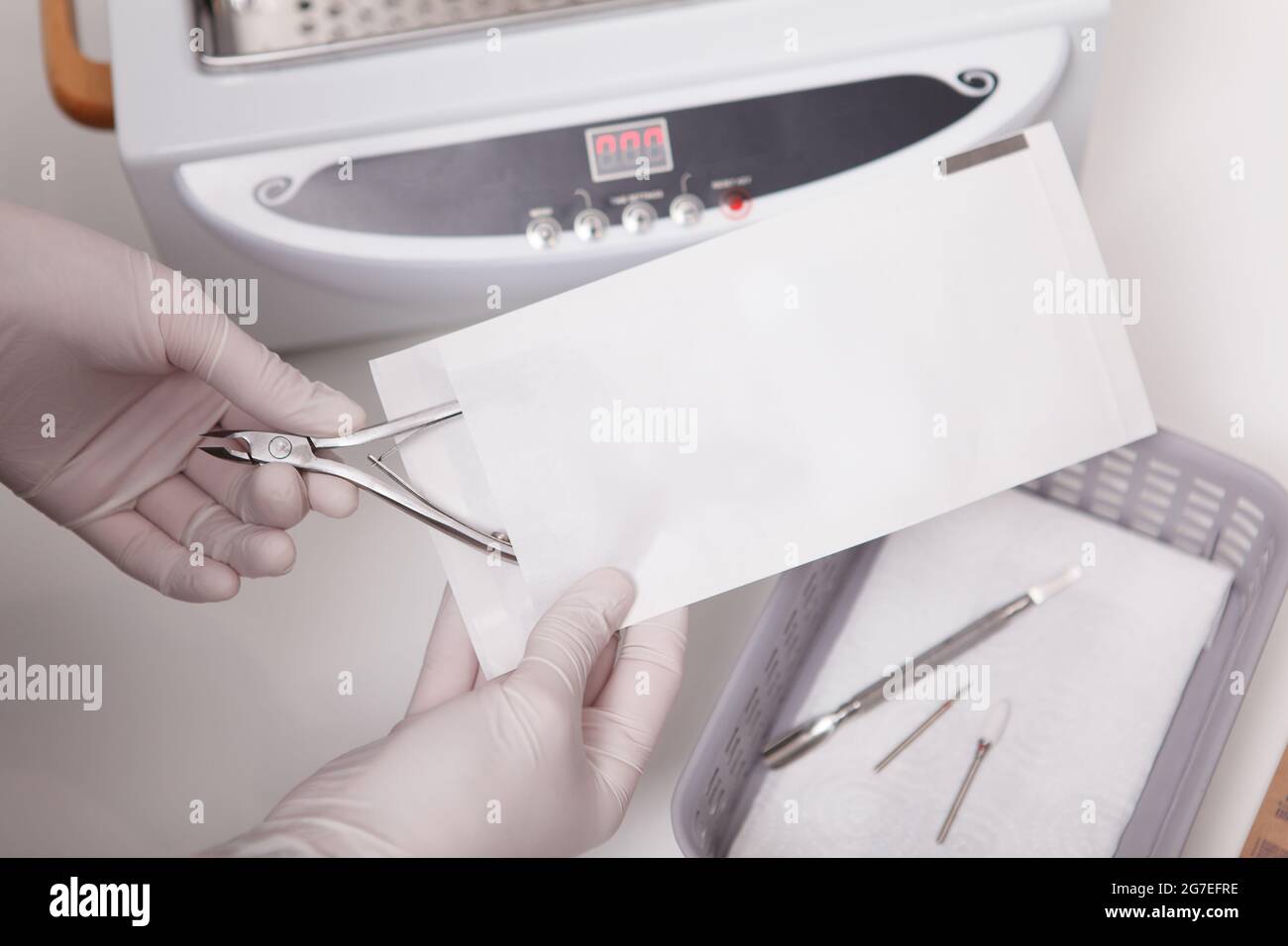 Unrecognizable manicurist putting nail nippers in paper envelope for ...