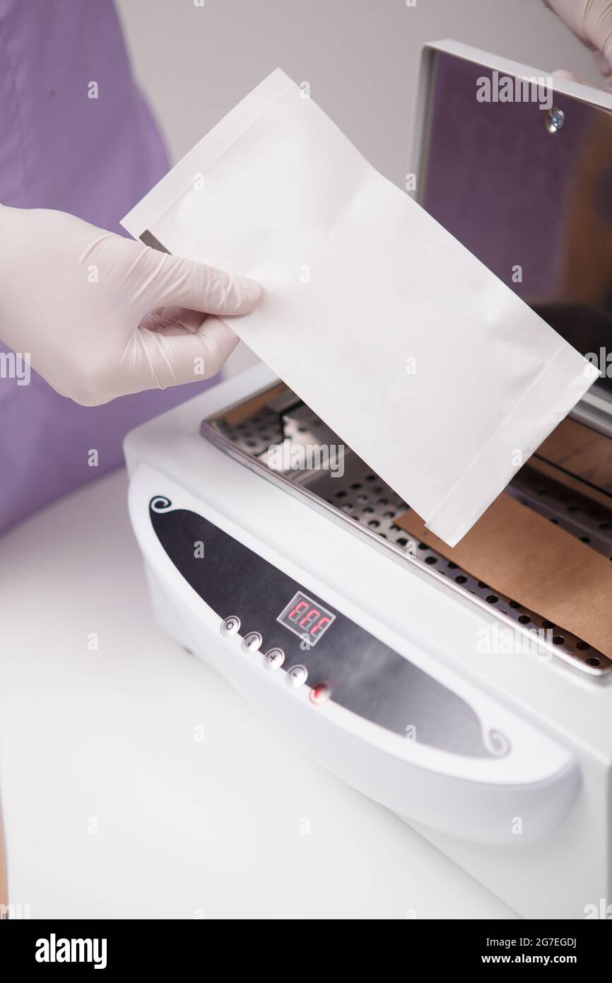 Vertical cropped shot of professional manicurist using dry heat ...