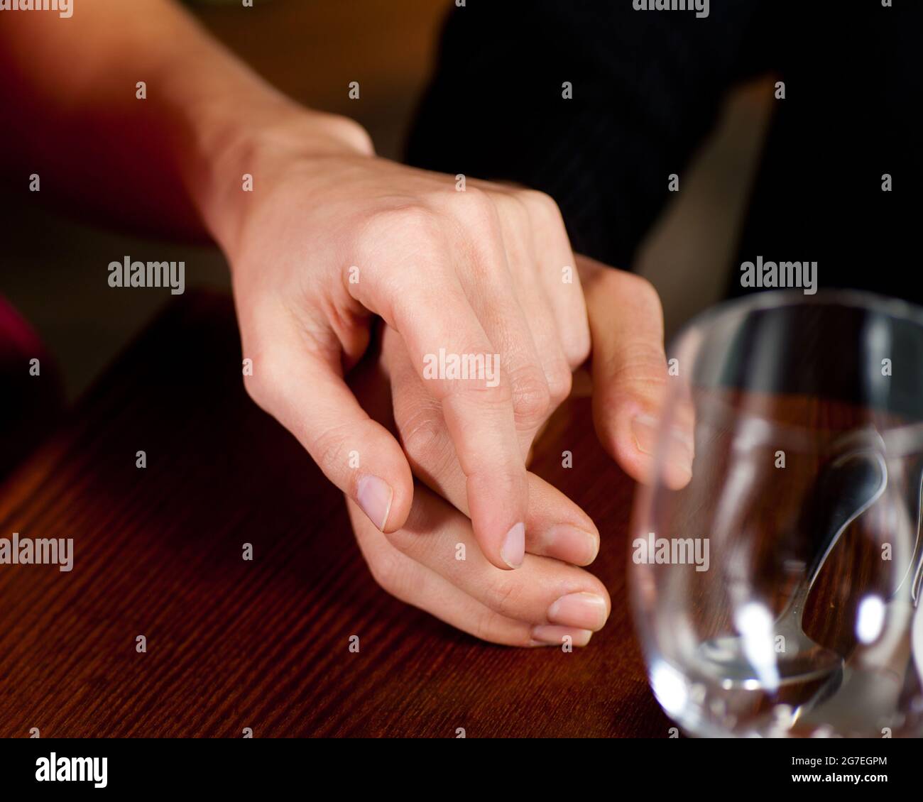Couple holding hands on a table, probably in a restaurant Stock Photo ...