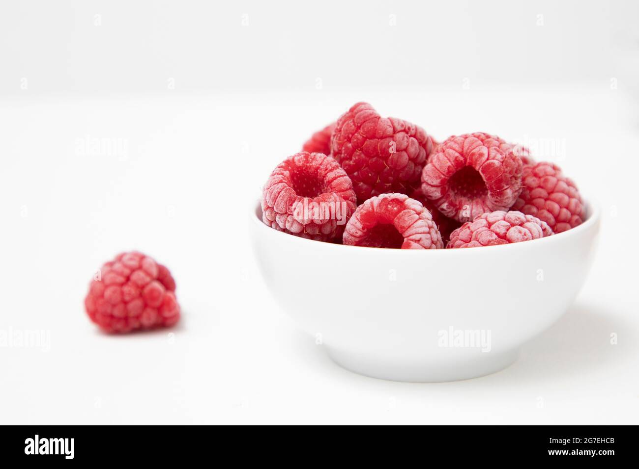 Frozen Raspberries in a white bowl on a white background Stock Photo ...