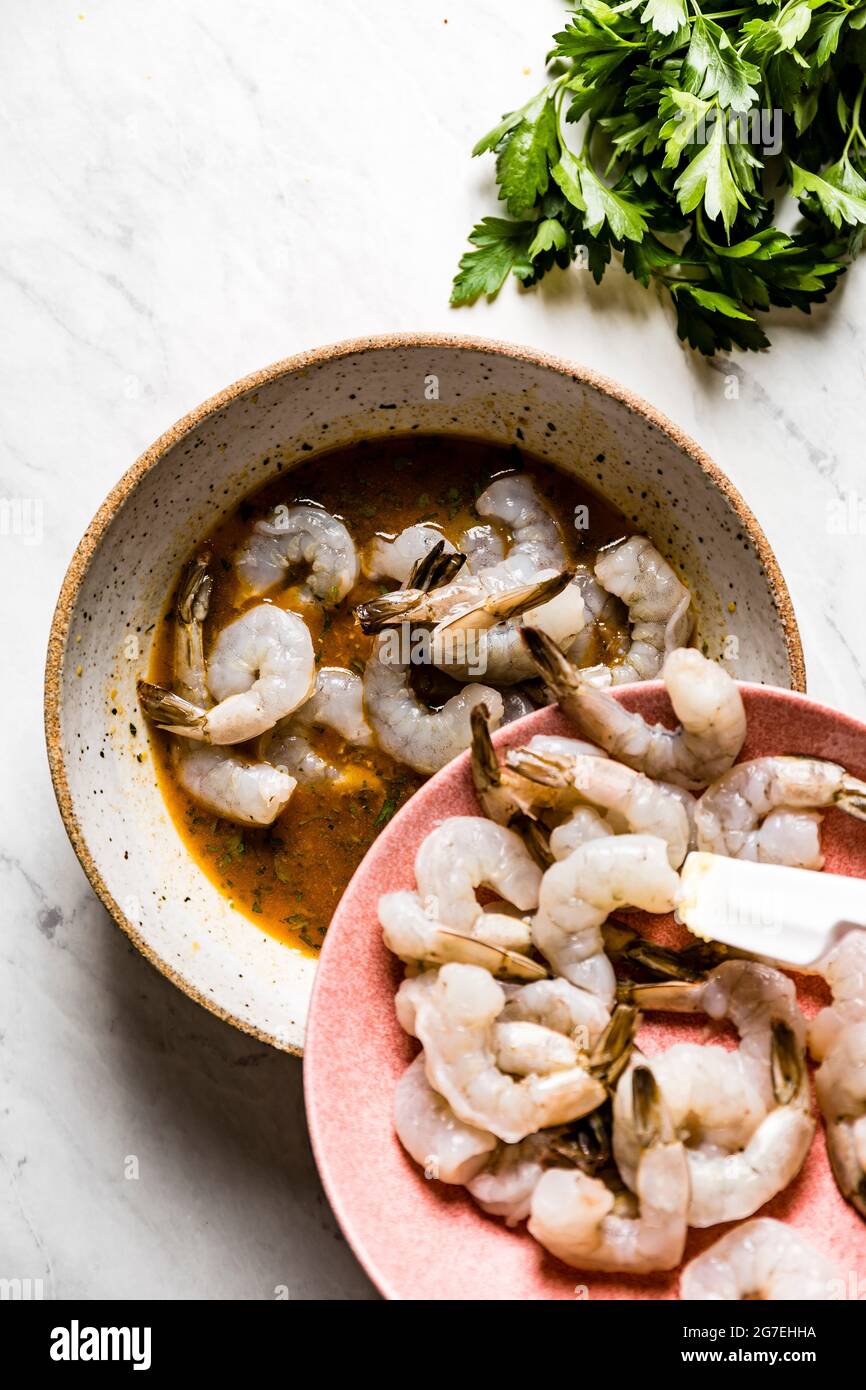 Shrimp in a homemade marinade ingredients, on a marble background Stock ...