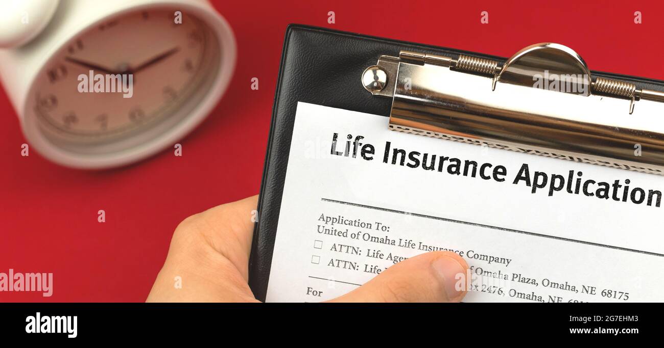 Man hold Life insurance claim form. Office desk background with alam ...