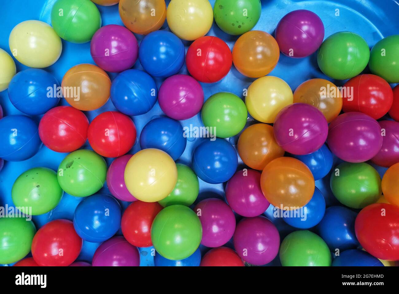 Overhead shot of colorful small balls in a blue base Stock Photo - Alamy
