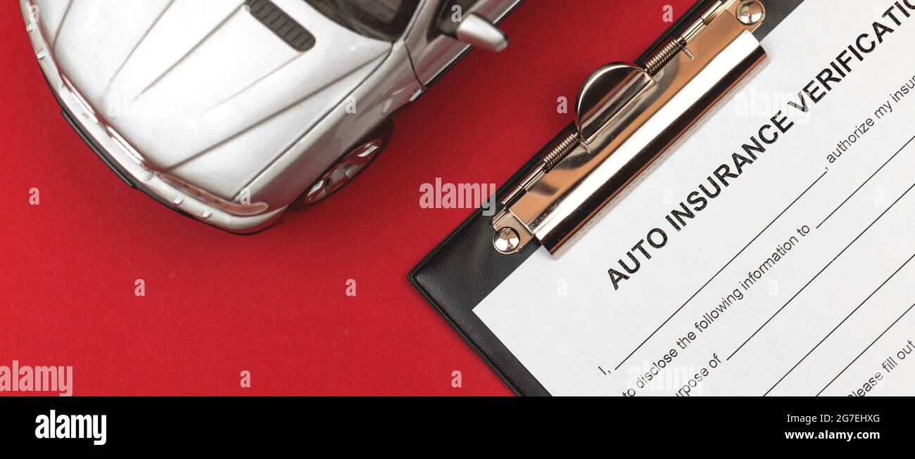 Auto insurance form. Office desk with clipboard and car toy on a red ...