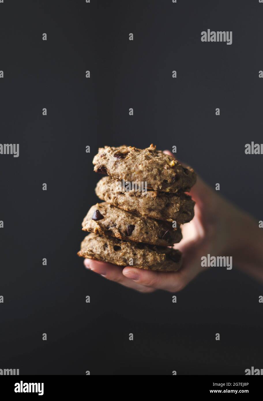 a hand holding a stack of chocolate chip cookies Stock Photo - Alamy