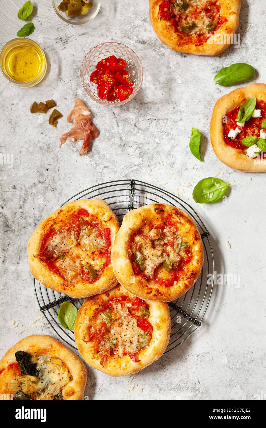 Mini pizzas - pizzette - topped with cheese and tomato plus Italian ham ...