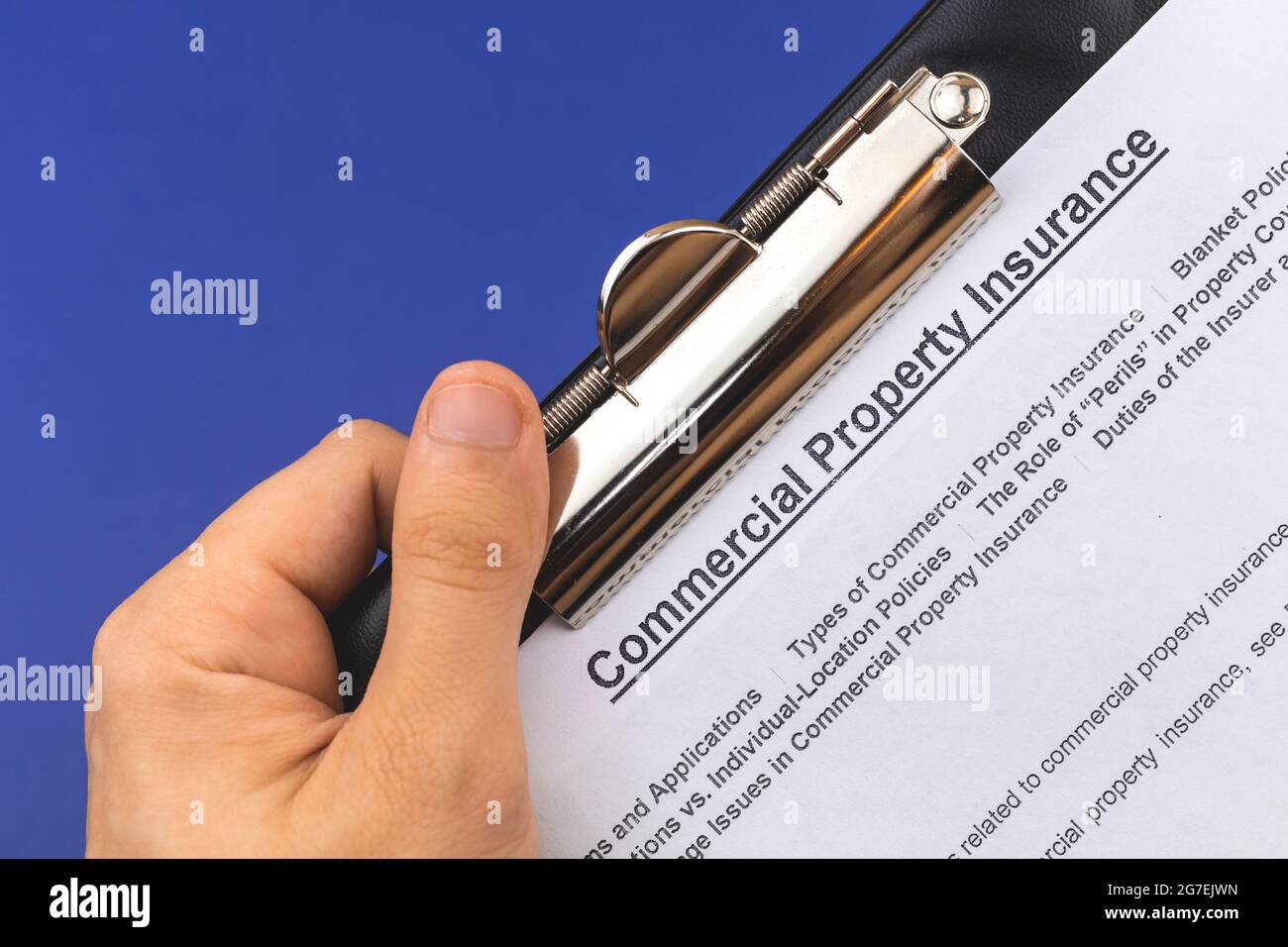 Man hold commercial property insurance claim form and policy in hand ...