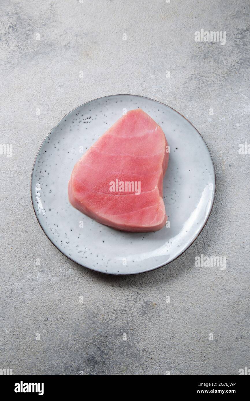 Fresh tuna steak on gray plate, gray background Stock Photo - Alamy